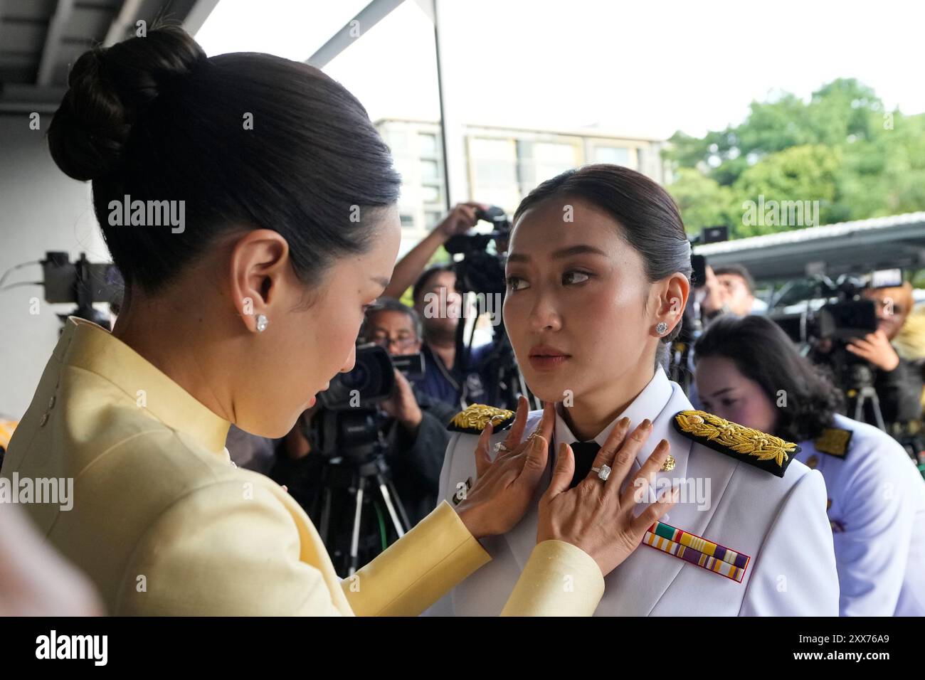 Pinthongta Shinawatra adjusts the collar of her younger sister, Thailand's newly elected Prime ...