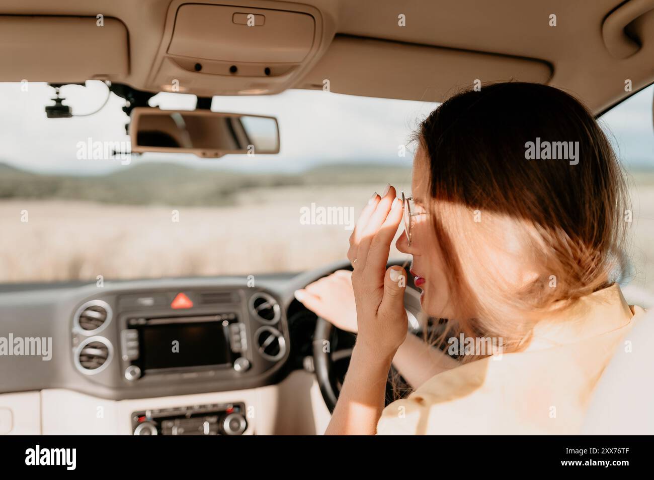 Woman Adjusting Glasses While Driving Stock Photo - Alamy