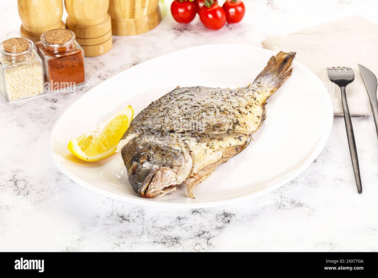 Baked Dorado fish served lemon slice Stock Photo - Alamy