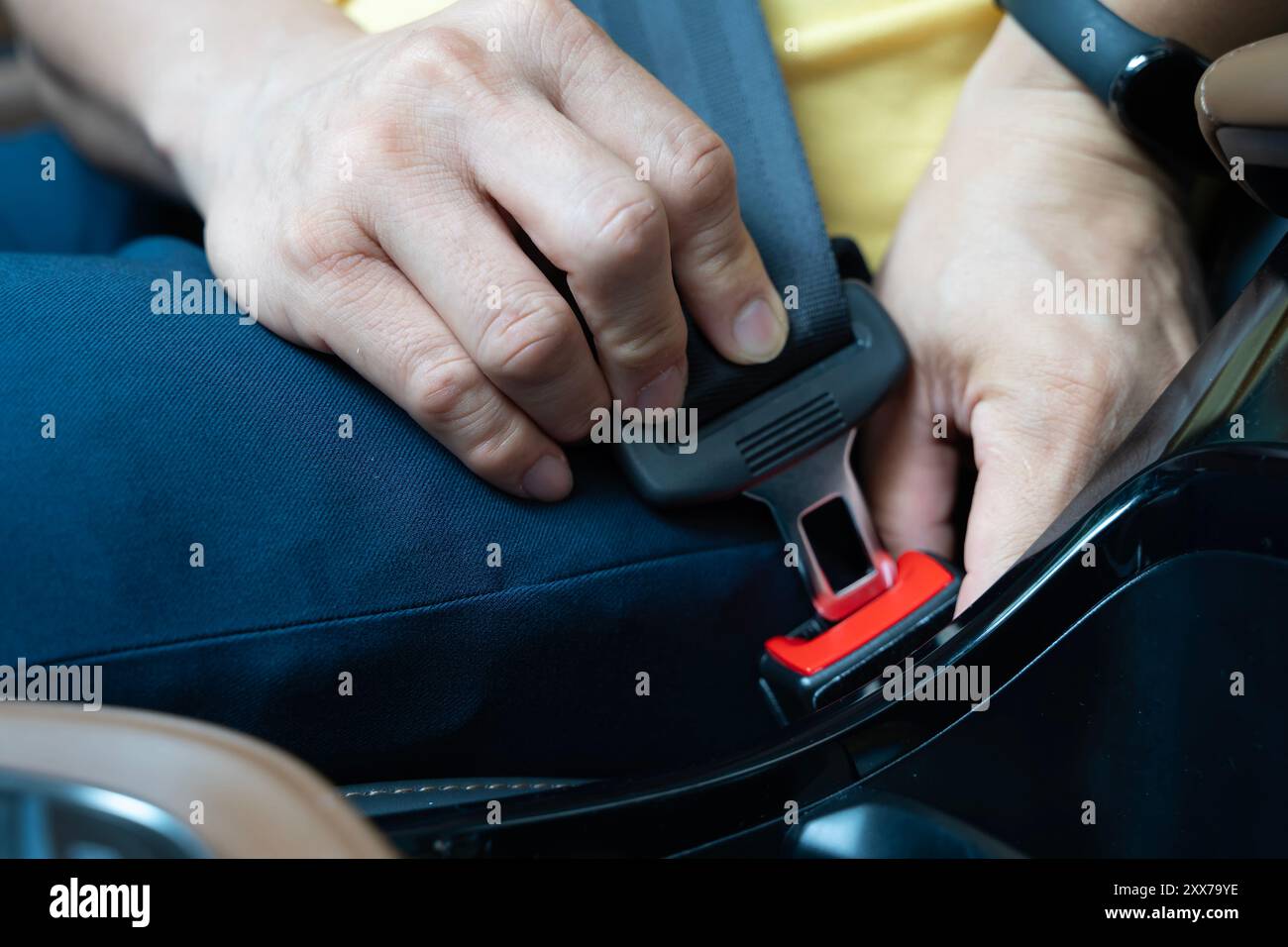 Buckling Up. Close up of man putting on seat belt in car, midsection ...