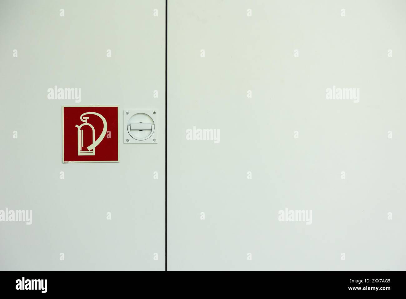 A white cabinet door with a red square symbol depicting a fire ...