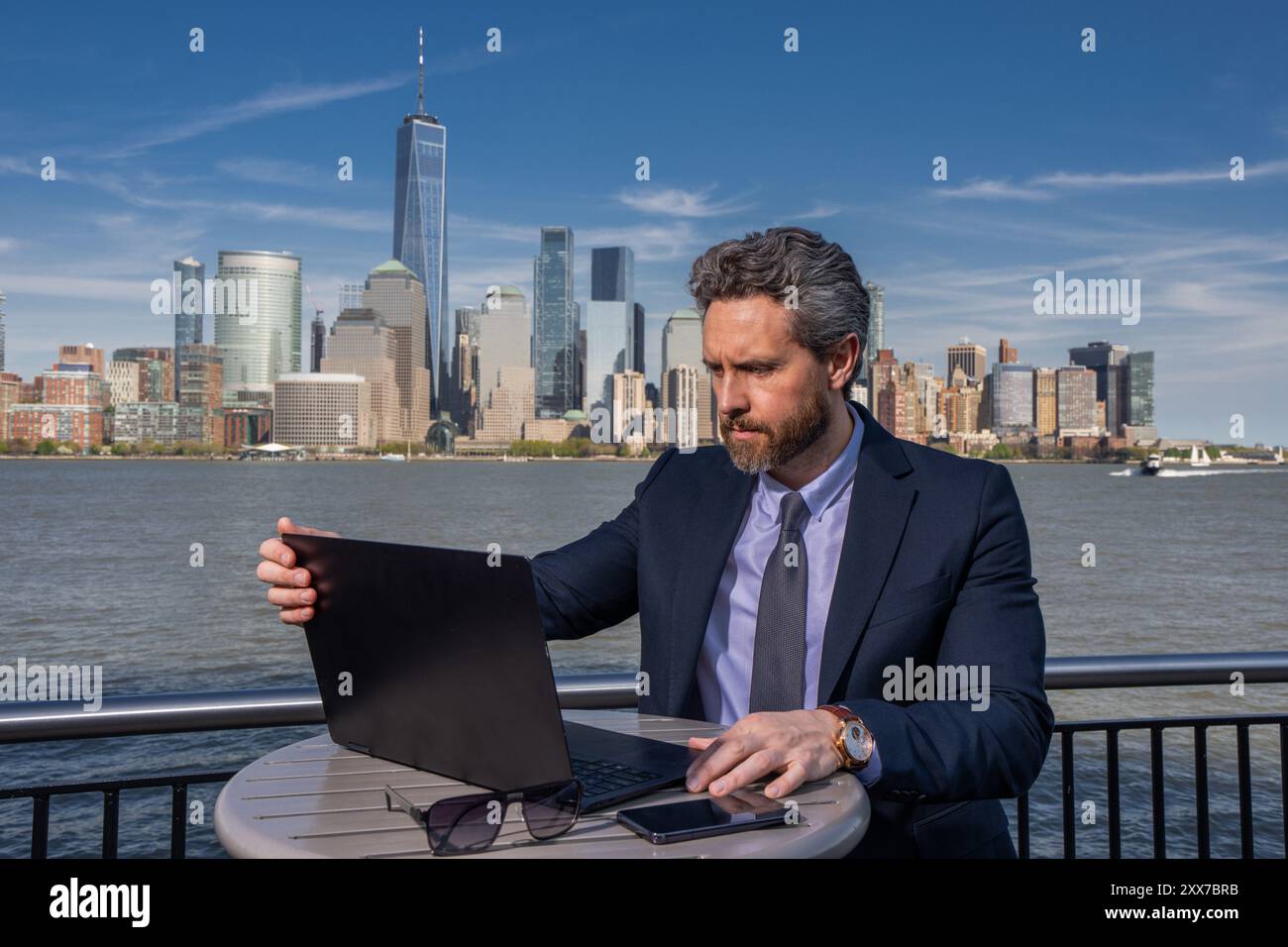 Successful USA businessman. Man using laptop outdoor in New York City ...