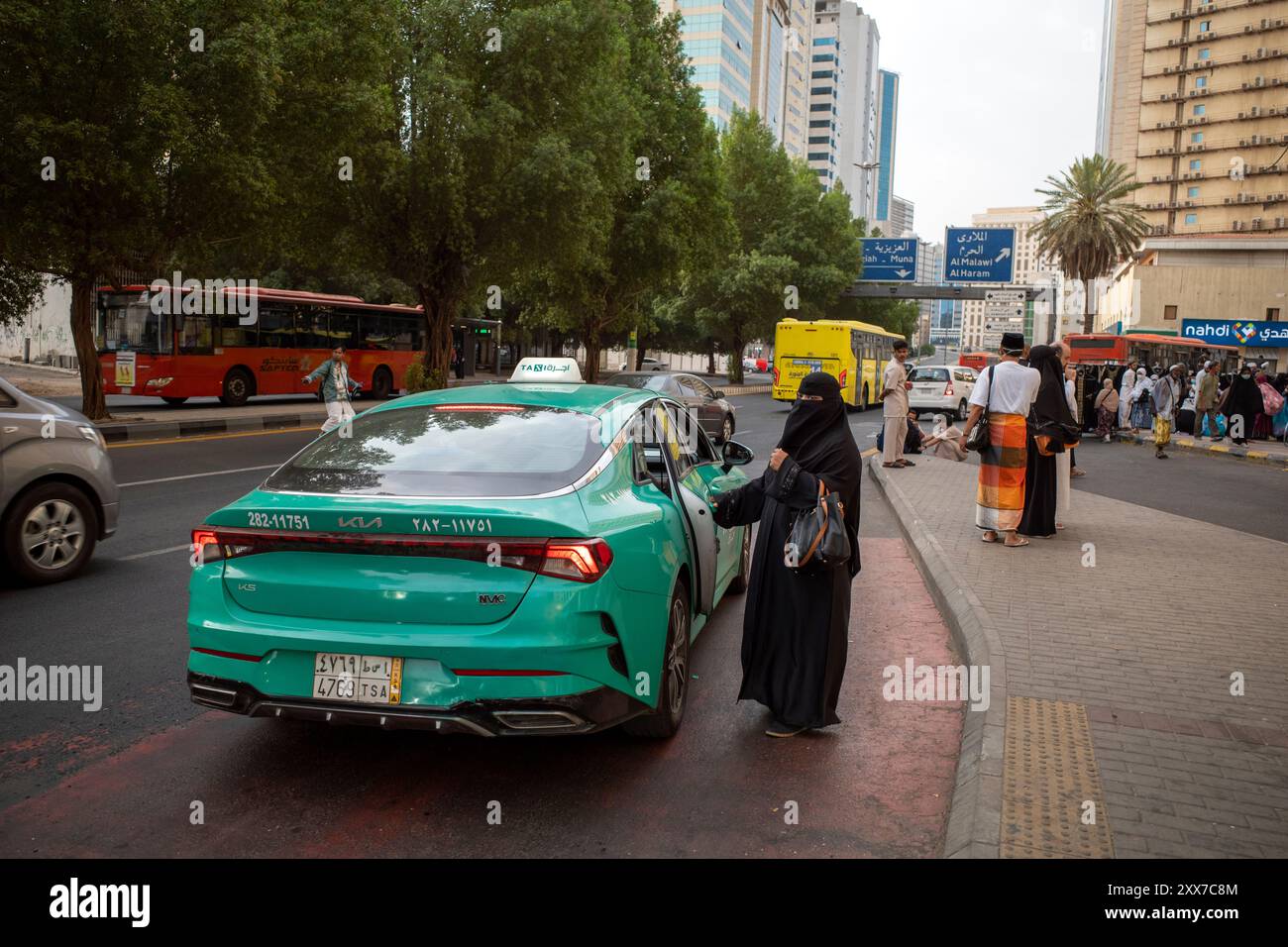 Mecca, Saudi Arabia - June 10, 2024: A woman in Saudi Arabia uses taxi during Hajj season in ...