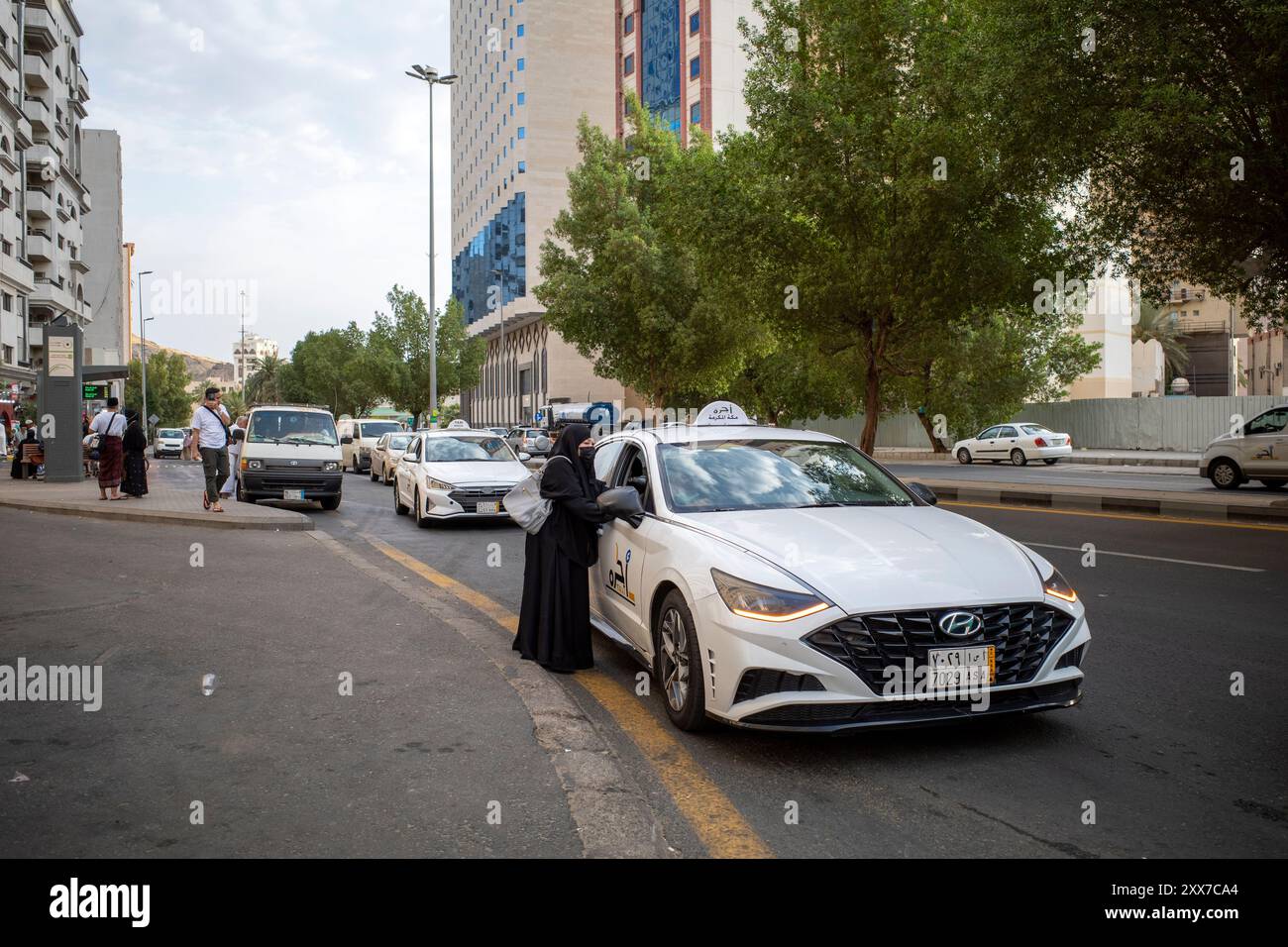Mecca, Saudi Arabia - June 12, 2024: A woman in Saudi Arabia uses taxi during Hajj season in ...