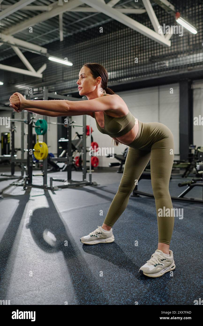 Young brunette stretching her back muscles in local gym Stock Photo - Alamy