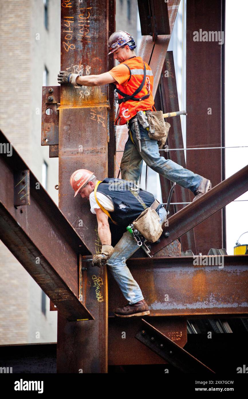 To bygningsarbeidere, eksperter på plassering og montering av T-bjelker ...