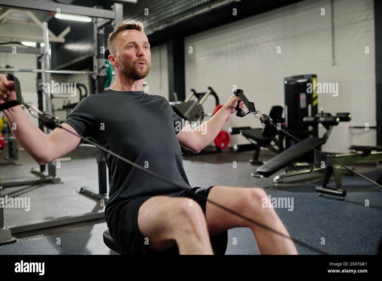 Bodybuilder having heavy workout in gym, he using horizontal pull ...