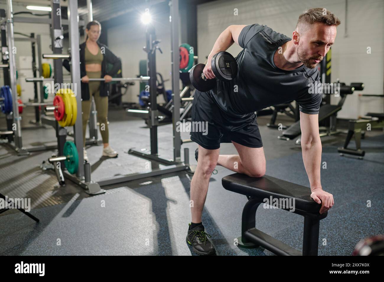 Professional sportsman doing bent over rows while his partner using ...