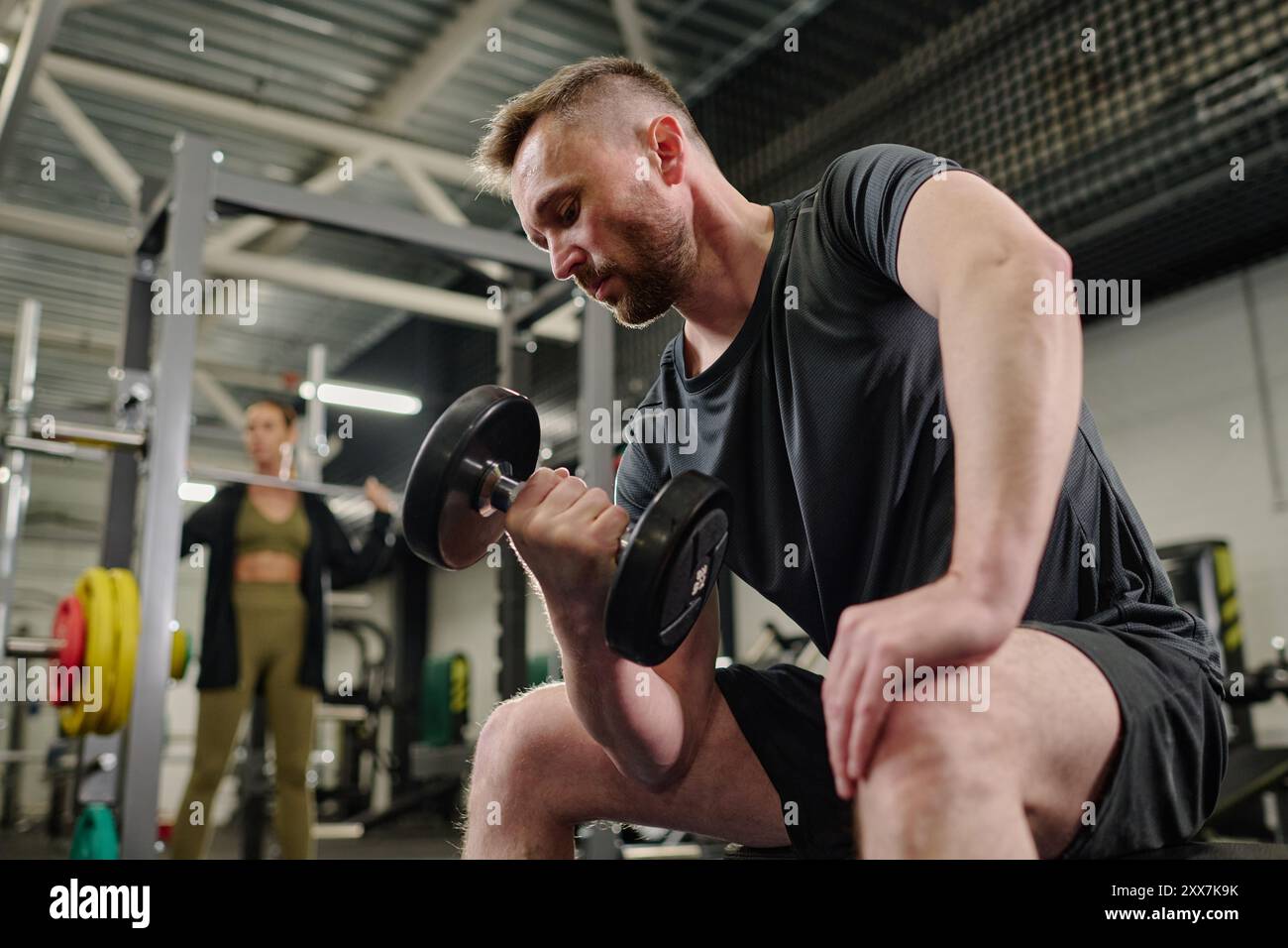 Low angle shot of man doing biceps exercise while his friend preparing ...