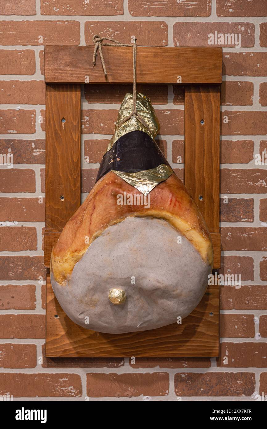 Hanging Raw Parma Ham Leg in front of a wall with exposed brickwork ...