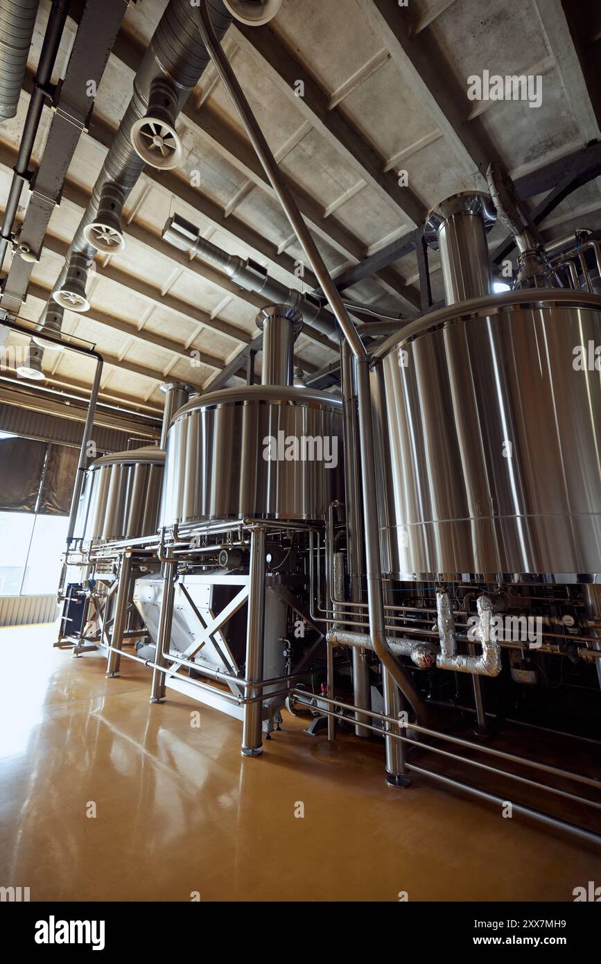 Large, modern brewery with several stainless steel fermentation tanks ...