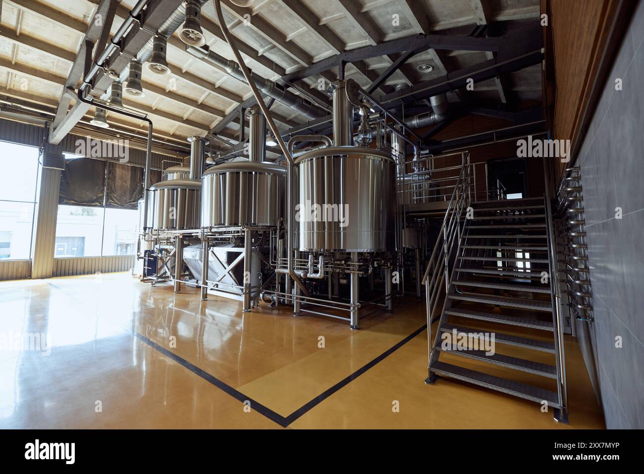 Large, modern brewery with several stainless steel tanks, connected by ...