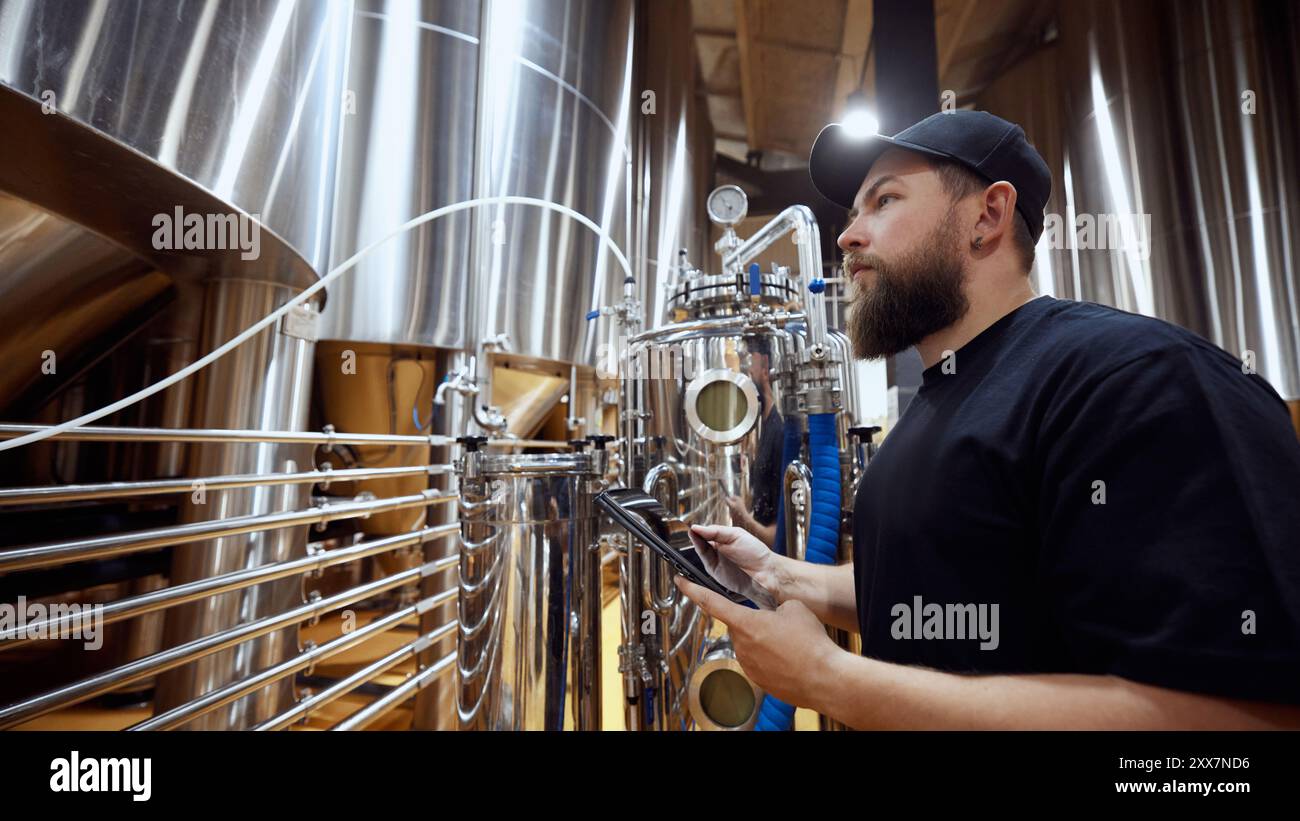 Brewery technologist, focused man checking fermentation process ...