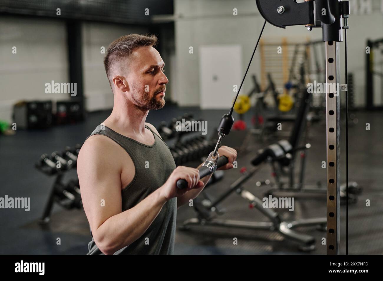 Male gym rat pumping his biceps while using weight machine Stock Photo ...