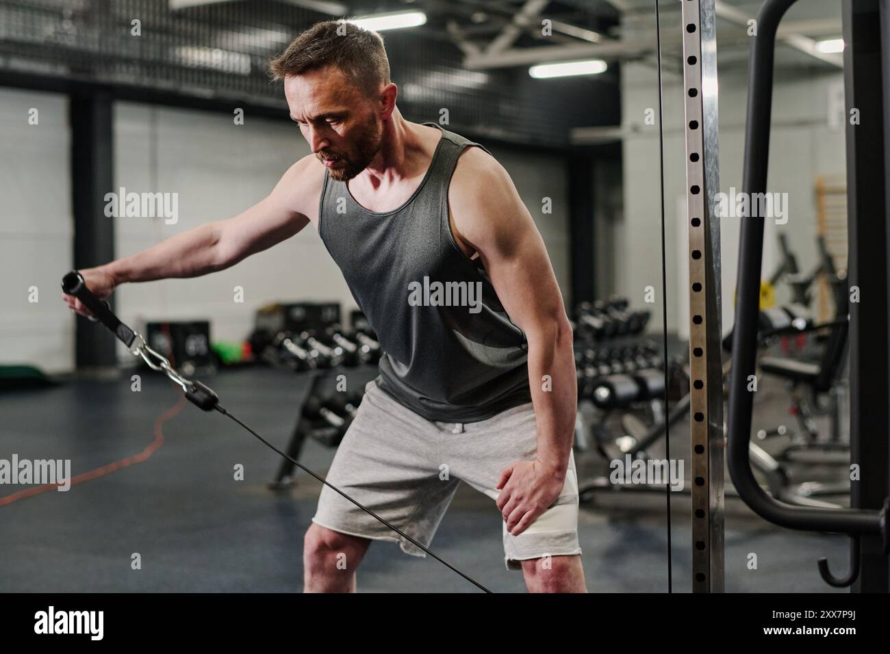 Highly motivated professional coach pumping his shoulder with help of ...