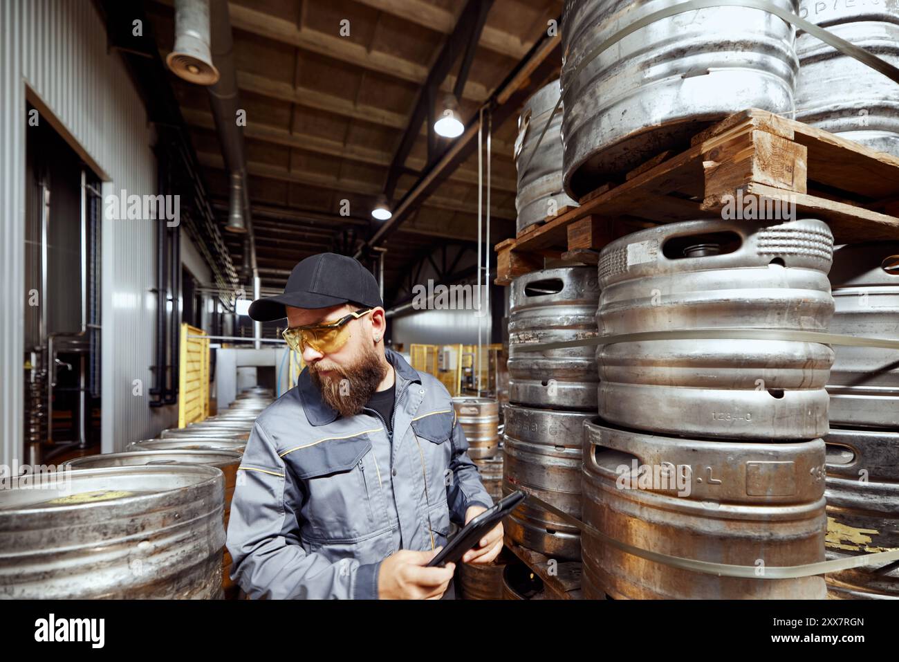 Concentrated man, brewery technologist, equipped with safety glasses ...