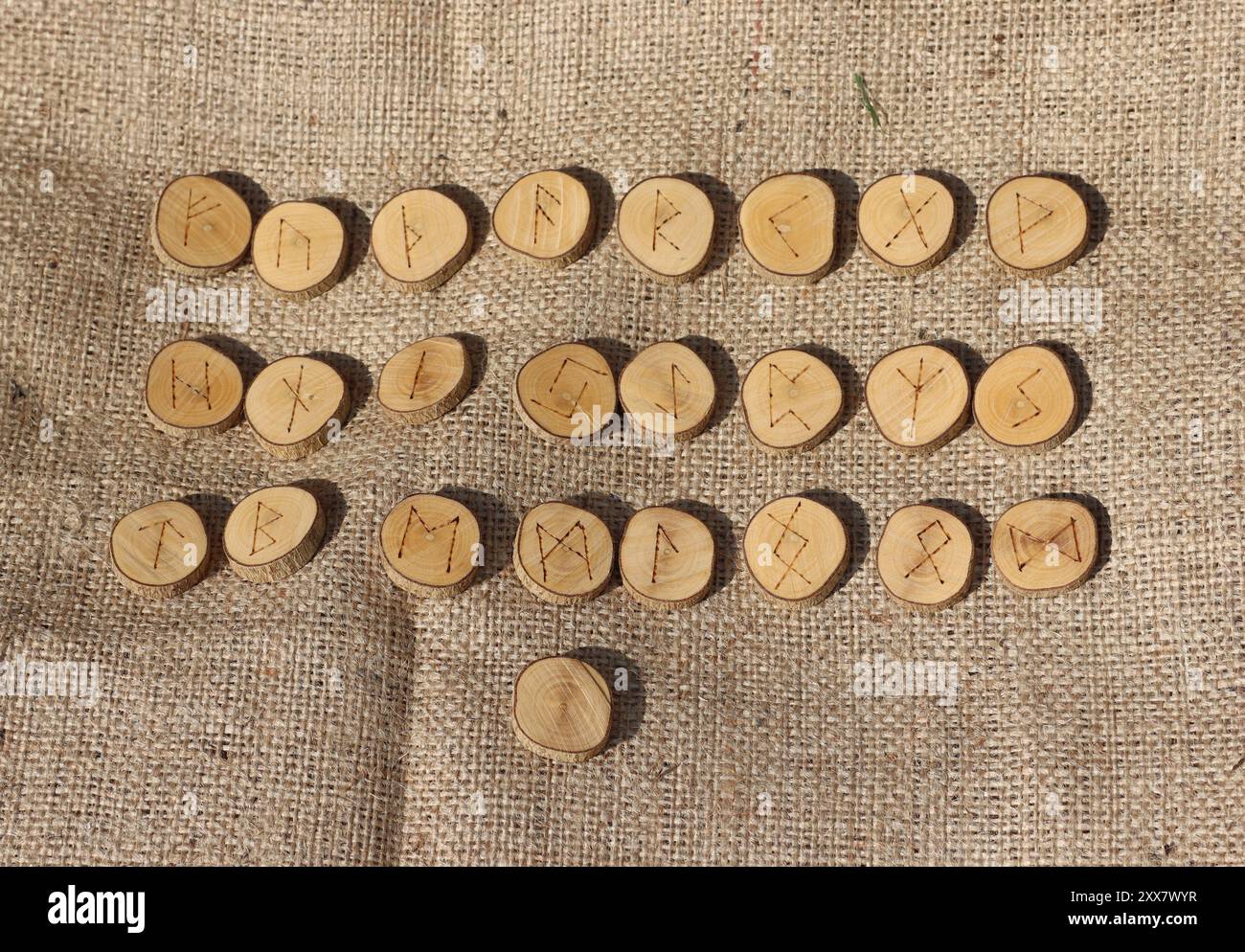 Viking runes carved into circles of wood laid on a sackcloth background ...