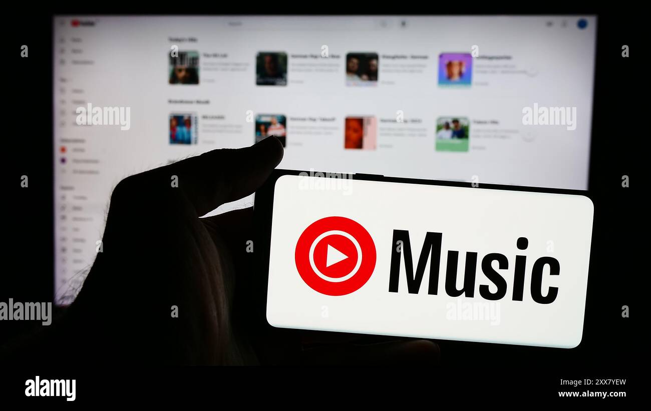 Person holding mobile phone with logo of American music streaming ...