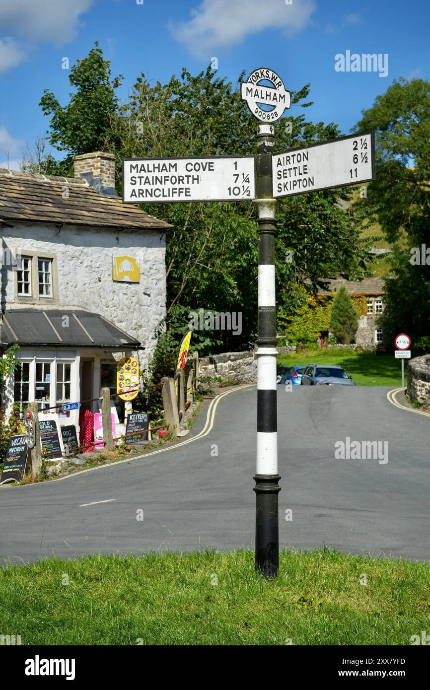 Vintage Iron road sign under a blue sky with rustic shop behind Stock ...