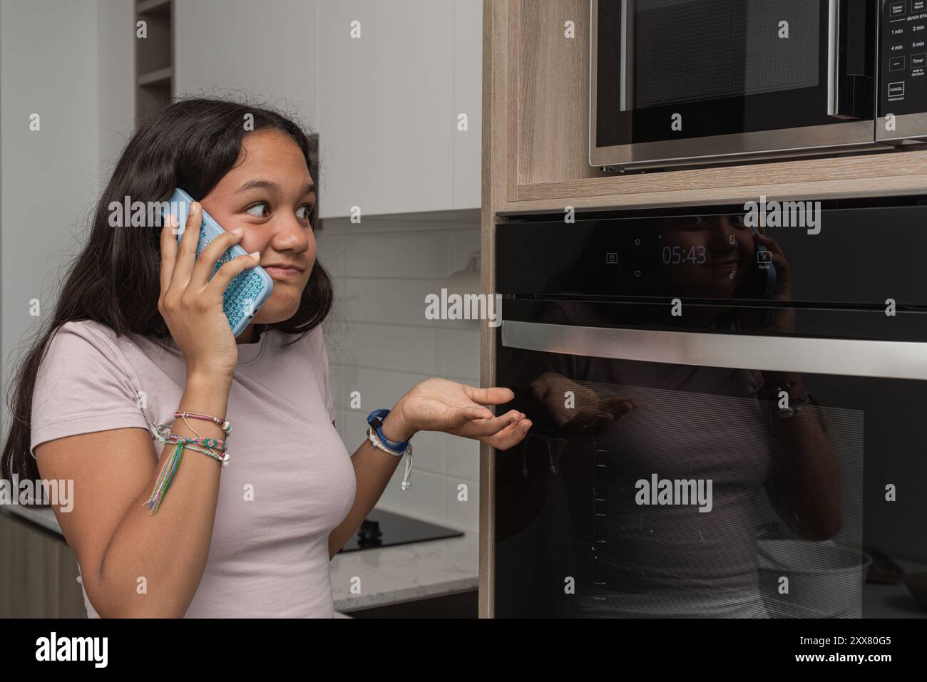 Teenager calling by phone to ask for help to cook Stock Photo - Alamy