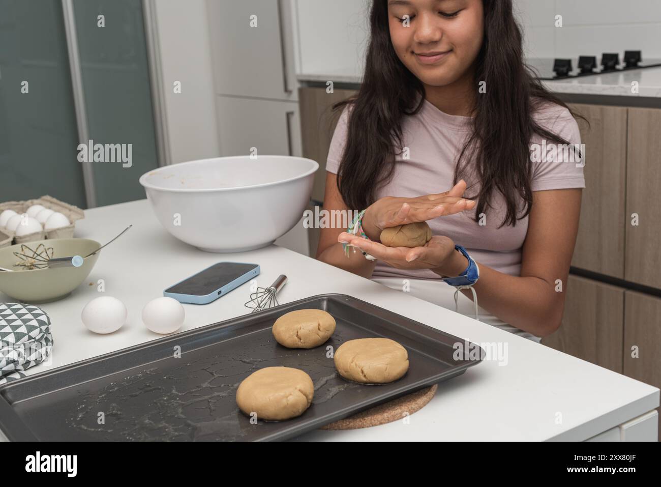 Young teenager shaping raw cookies Stock Photo - Alamy