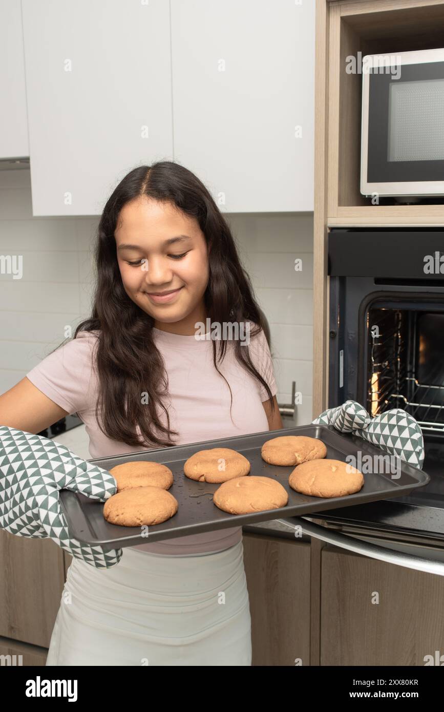 Happy girl showing off her freshly baked cookies at home Stock Photo ...