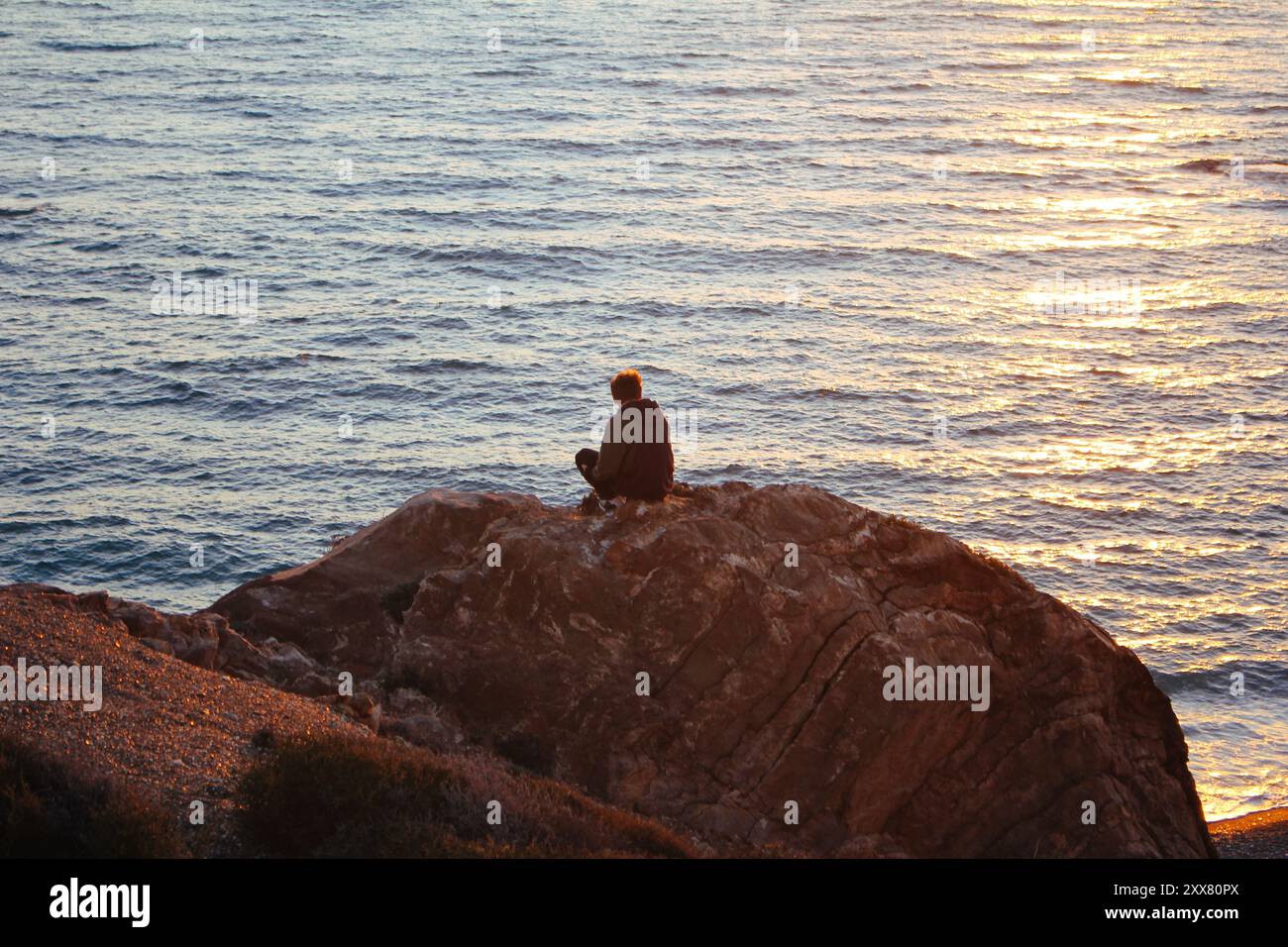 Figure sits on rocky hi-res stock photography and images - Alamy