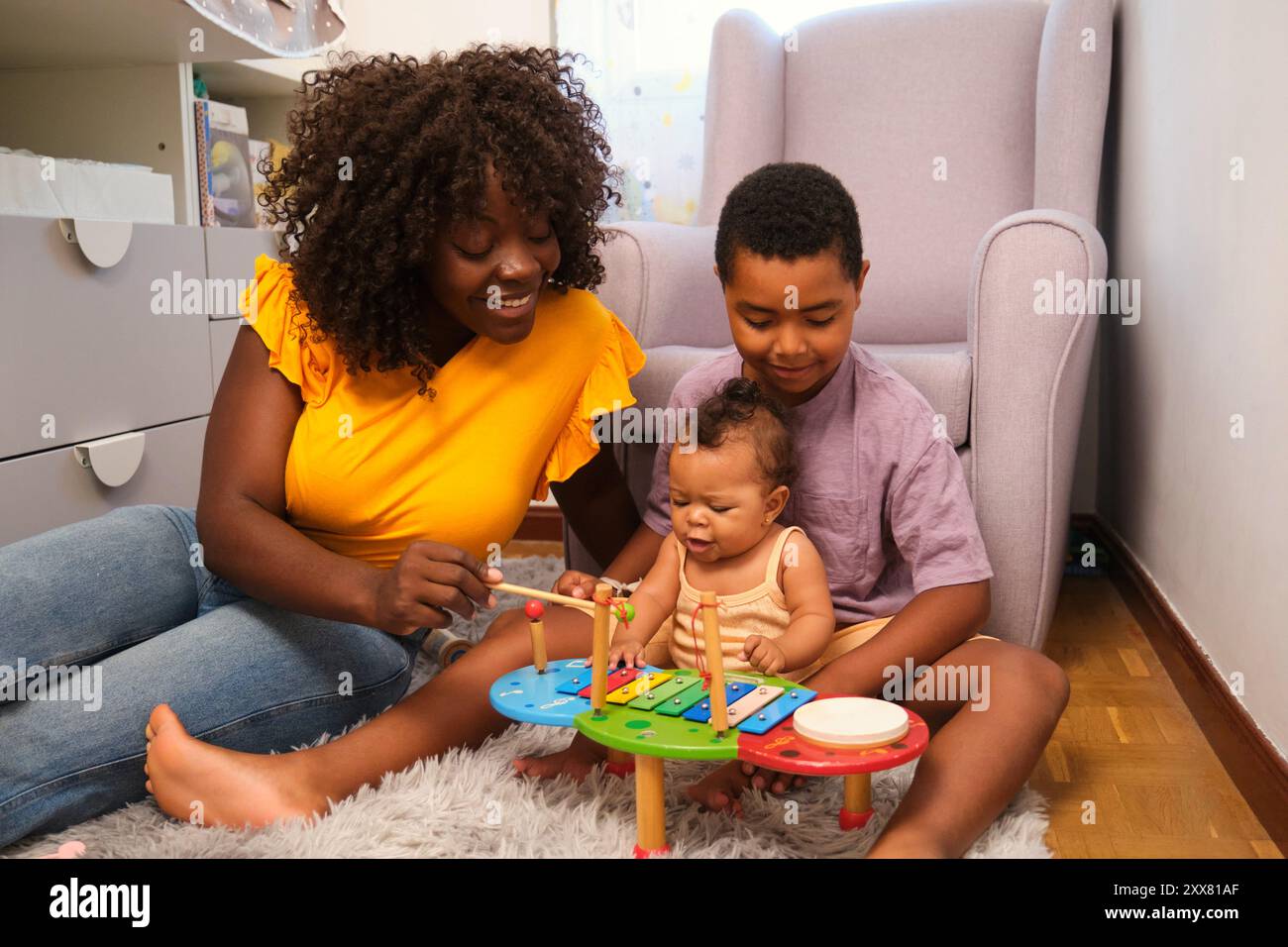 Happy family playing music with xylophone at home Stock Photo - Alamy