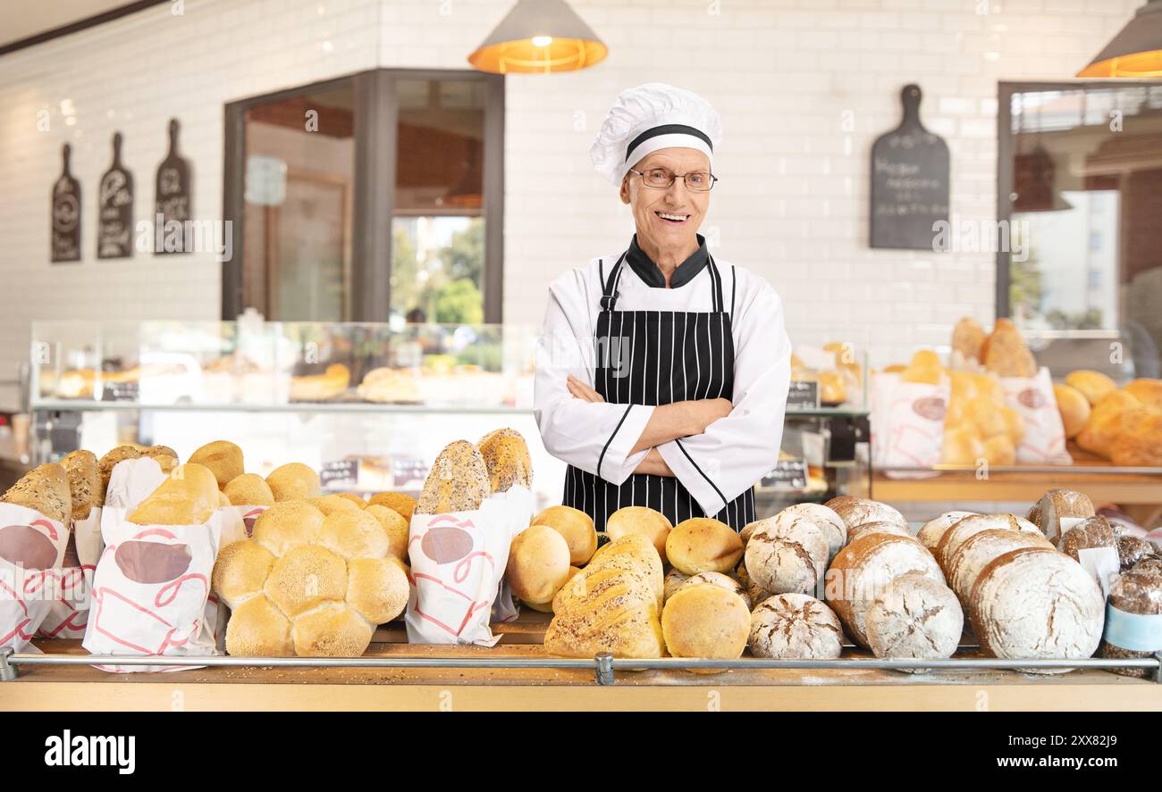 Bakery clerk standing behind breads on a shelf in a bakery Stock Photo ...
