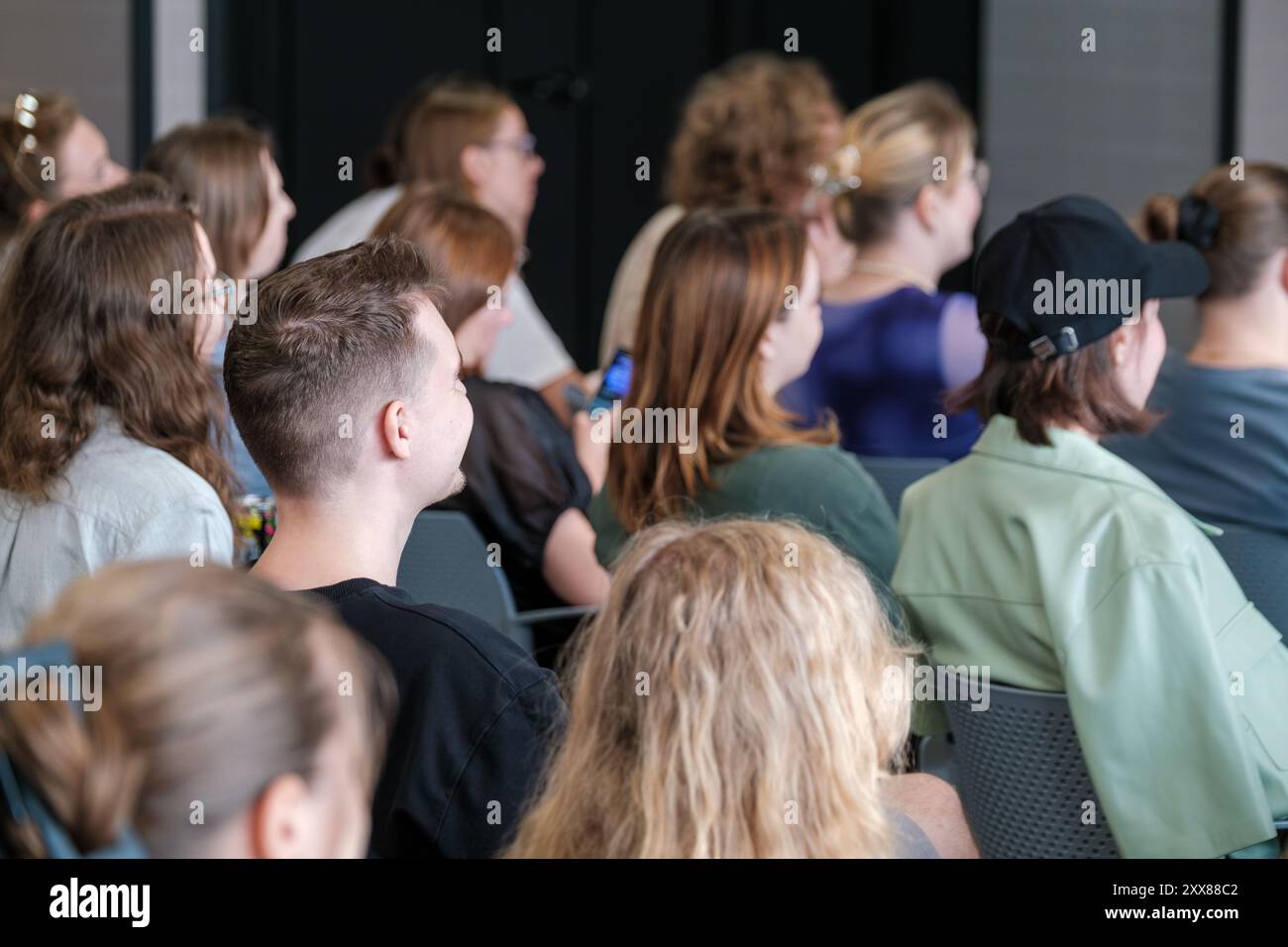 Audience seated in a conference room listening attentively to a speaker ...