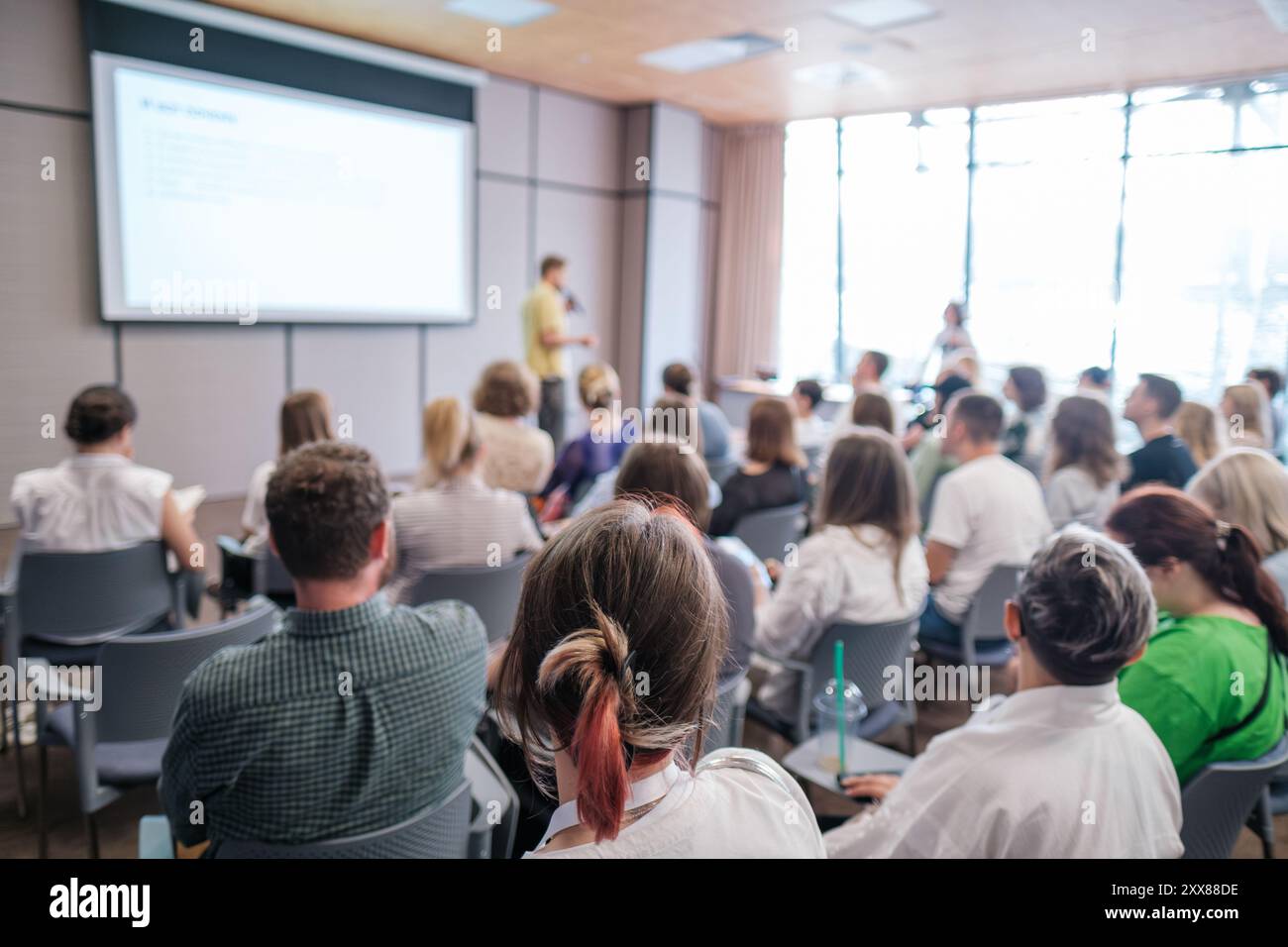 Diverse group of people attentively listening to speaker during ...