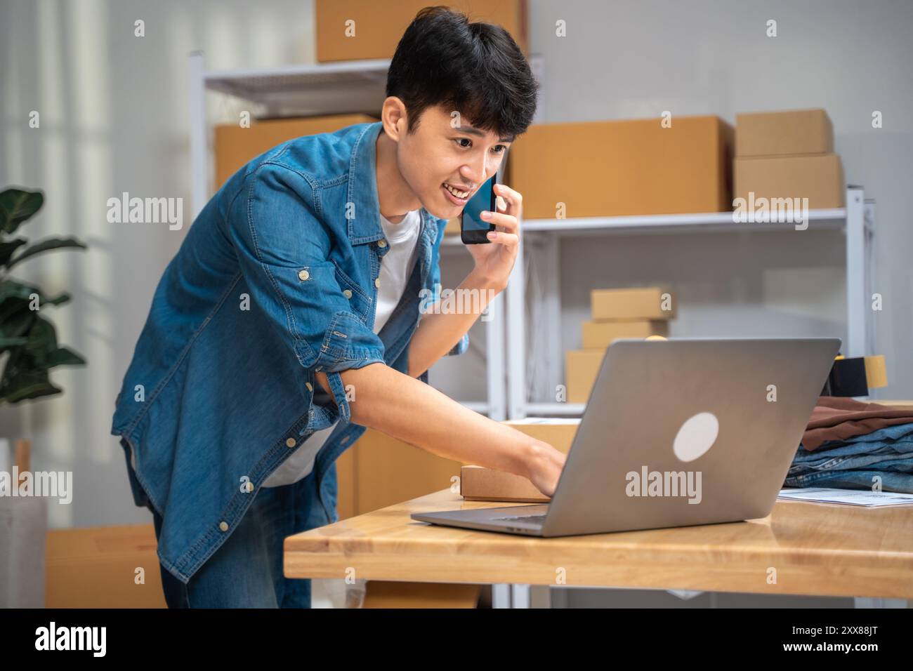 Happy young online seller man talking to his customer on the phone ...