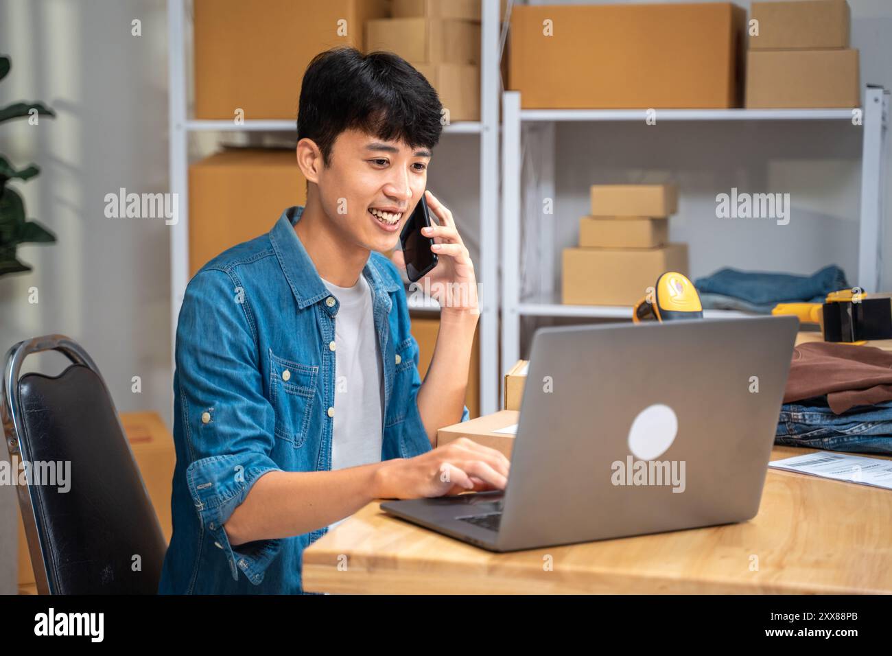 Happy young online seller man talking to his customer on the phone ...