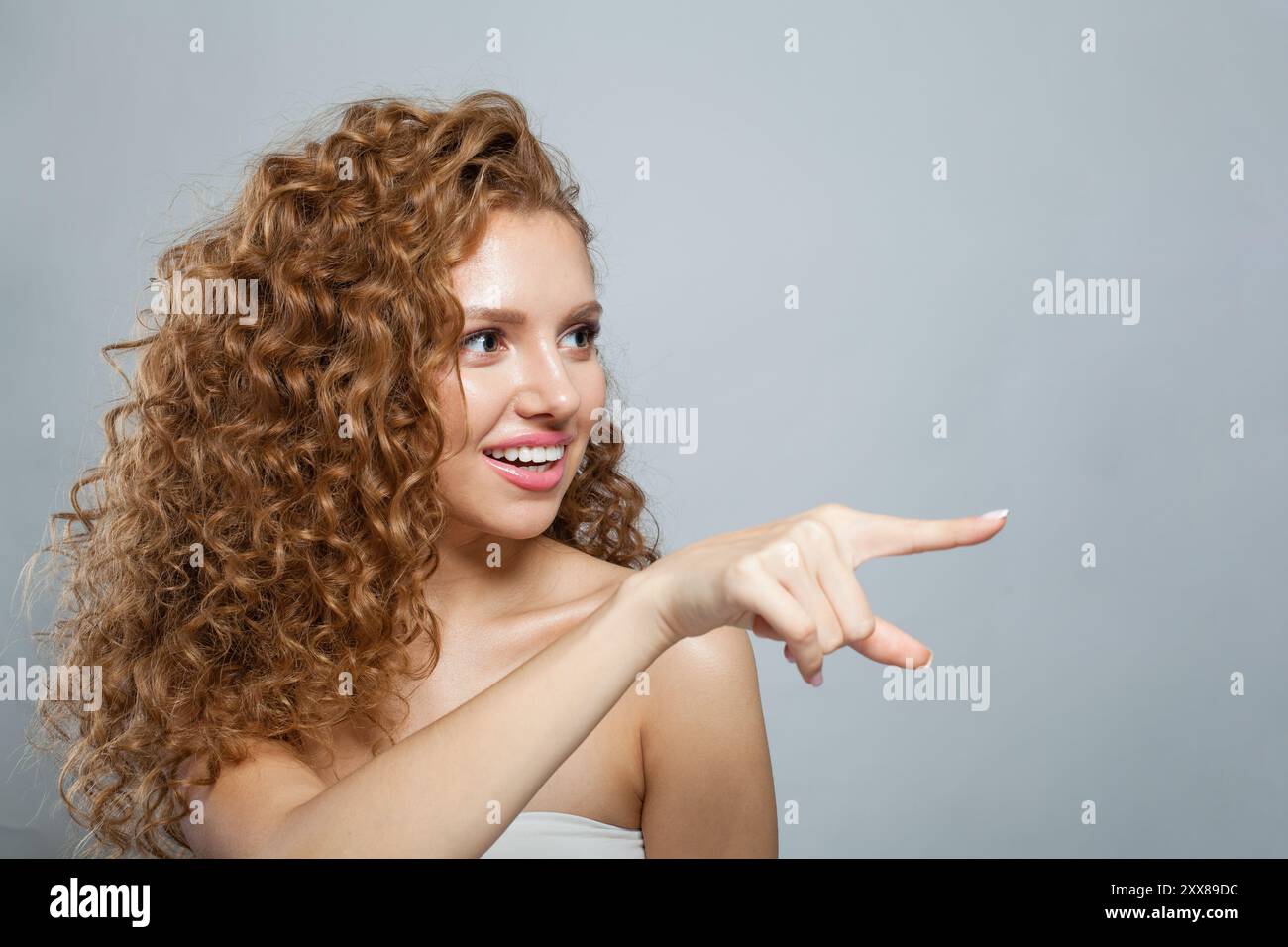 Female gesture. Pretty woman pointing finger on white background with ...