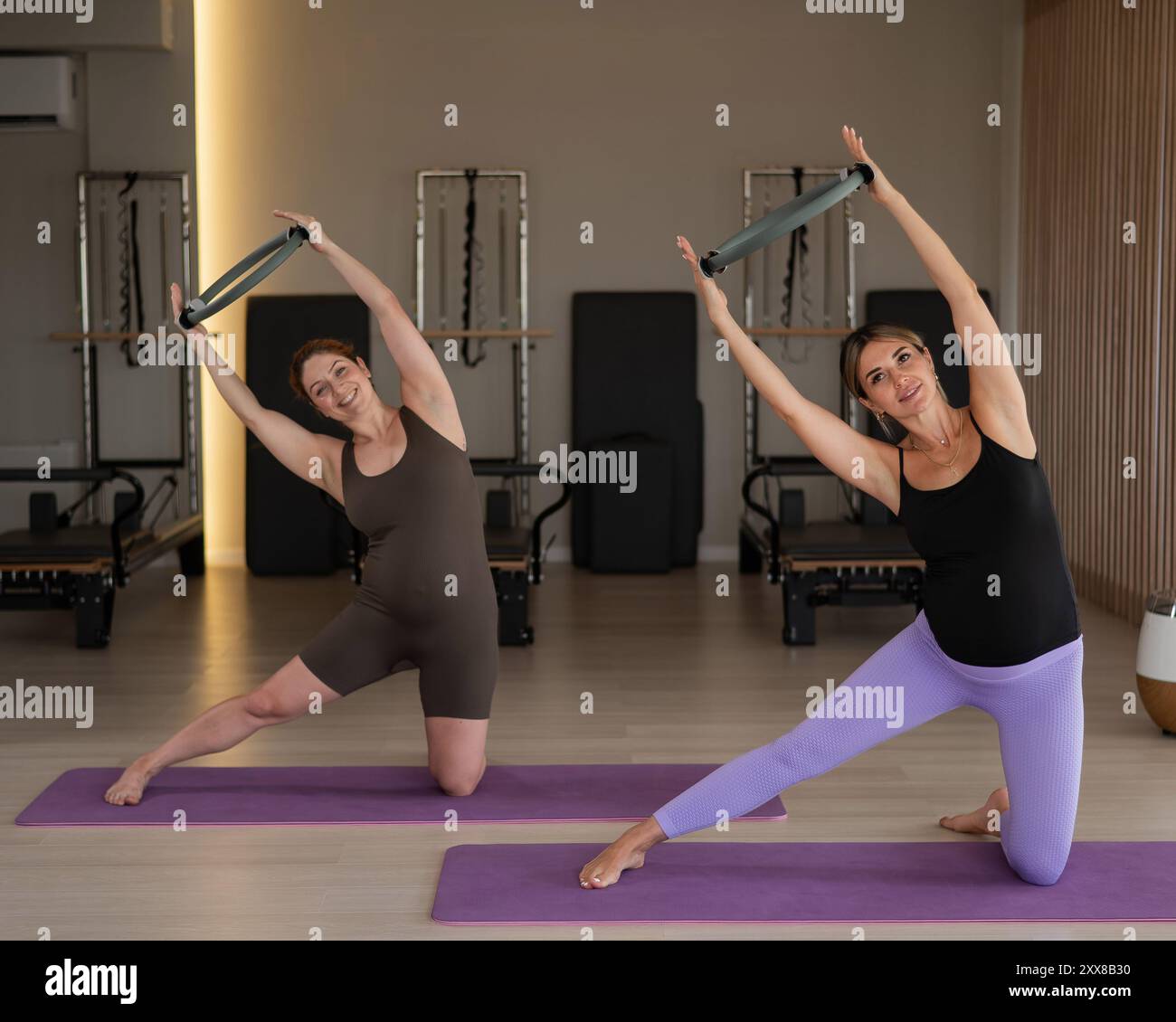 Two pregnant women doing yoga. Exercises with a gymnastic circle for ...