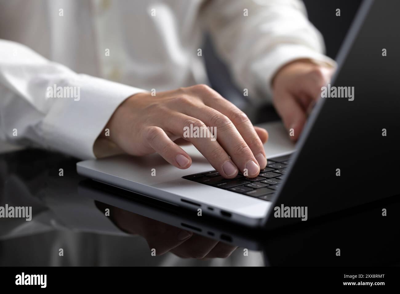 The businessman is focused on his laptop, working diligently at his ...