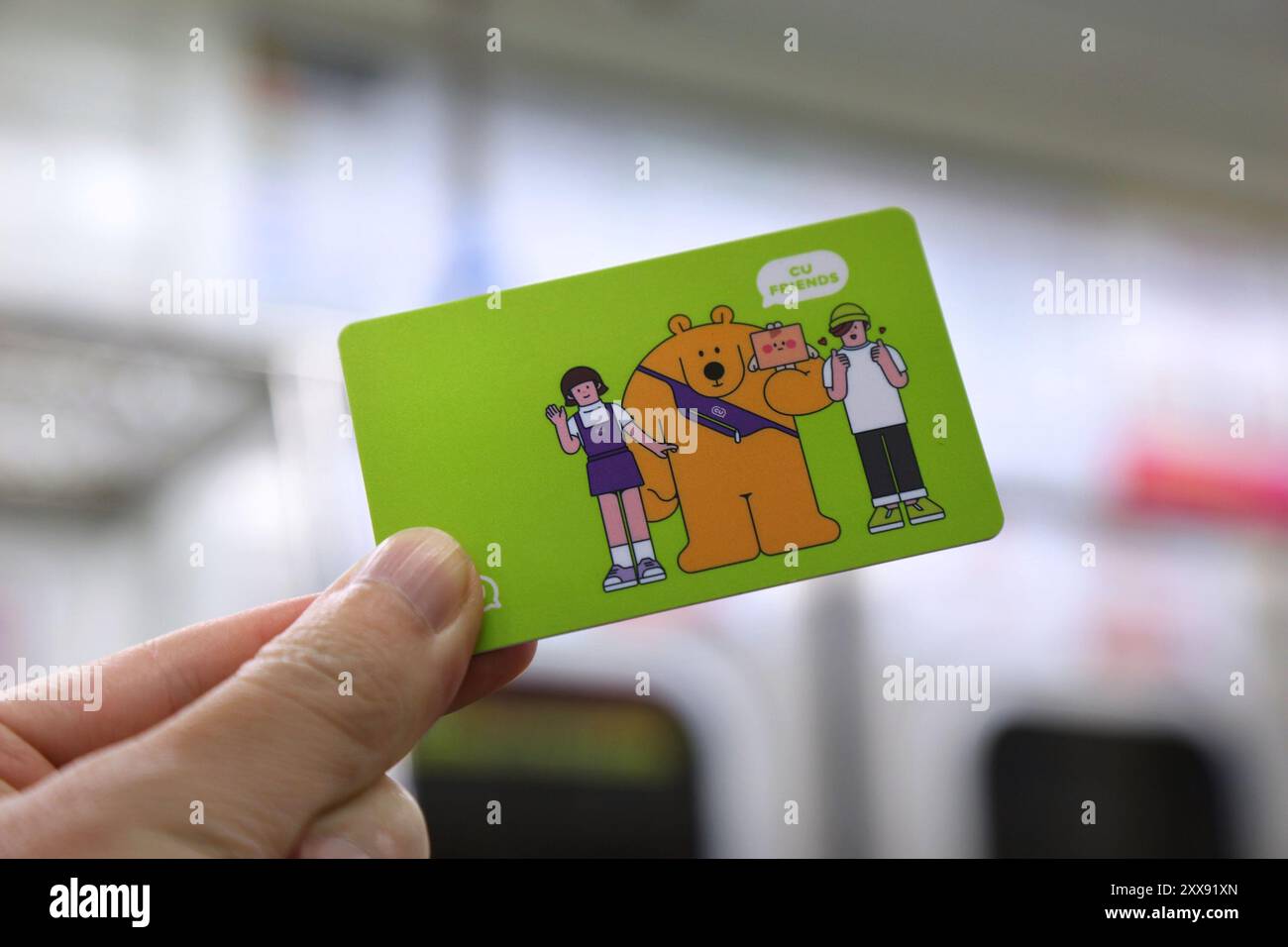 BUSAN, SOUTH KOREA - MARCH 30, 2023: Passenger holds CU Cashbee transportation card at Busan ...