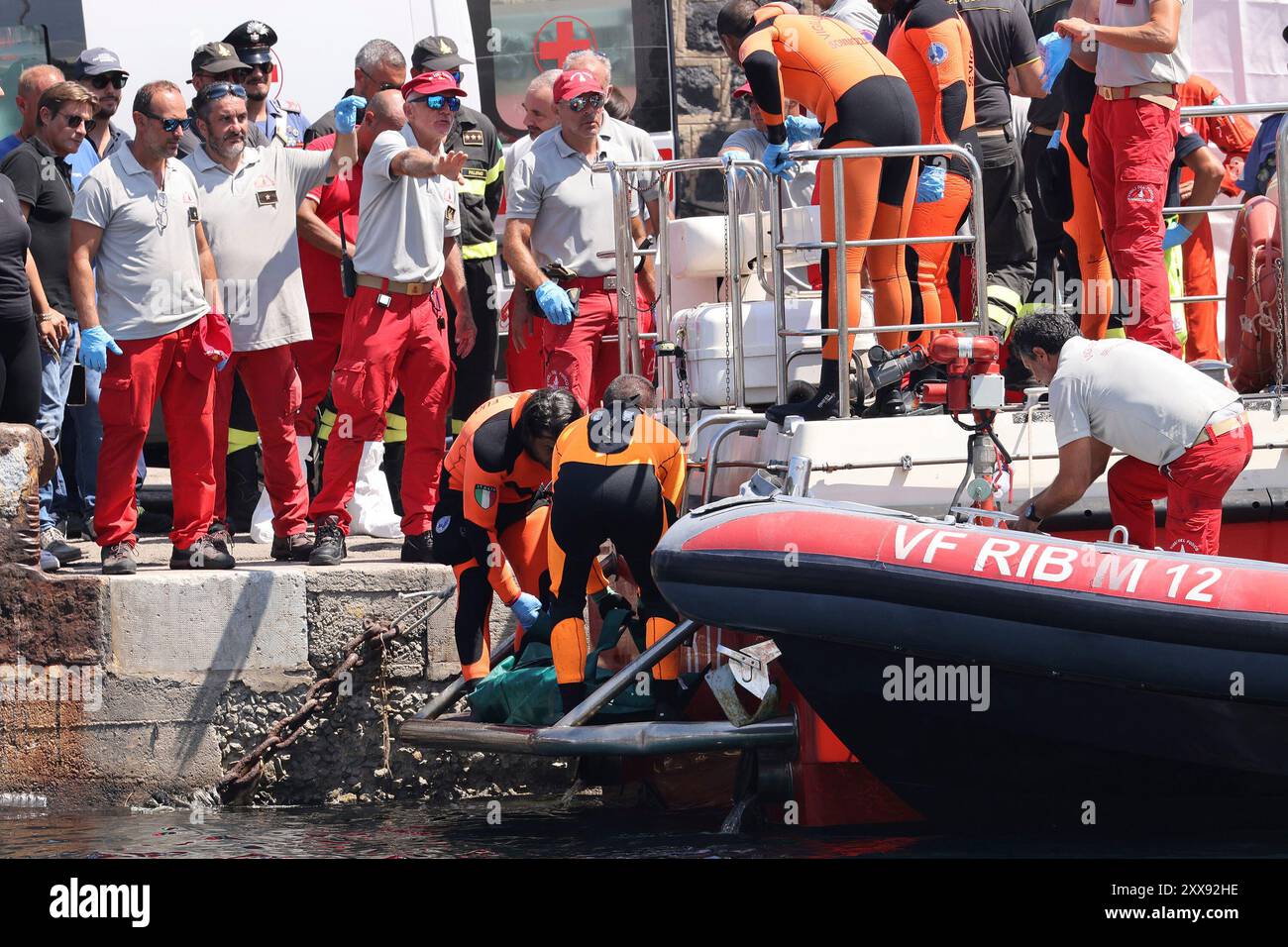 Italian firefighter divers bring ashore in a plastic bag the body of ...