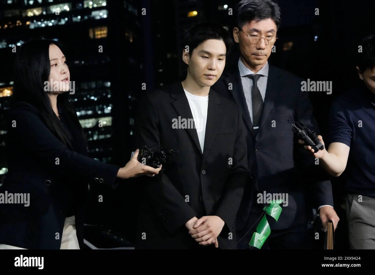 K-pop Band BTS Member Suga, second from left, arrives for questioning ...
