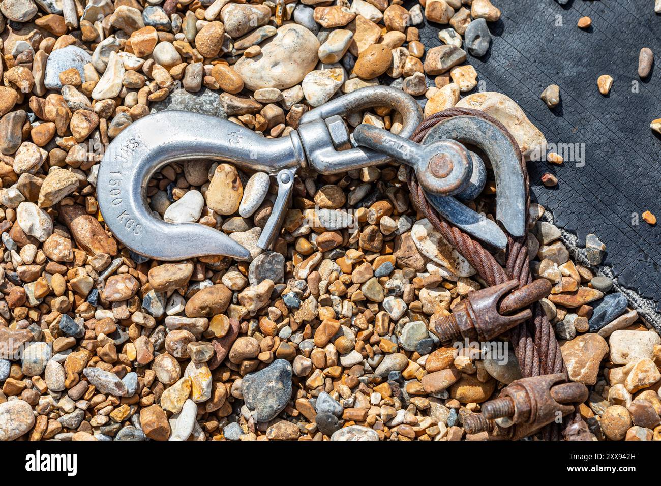 A metal towing hook and wire rope on a shingle beach Stock Photo - Alamy