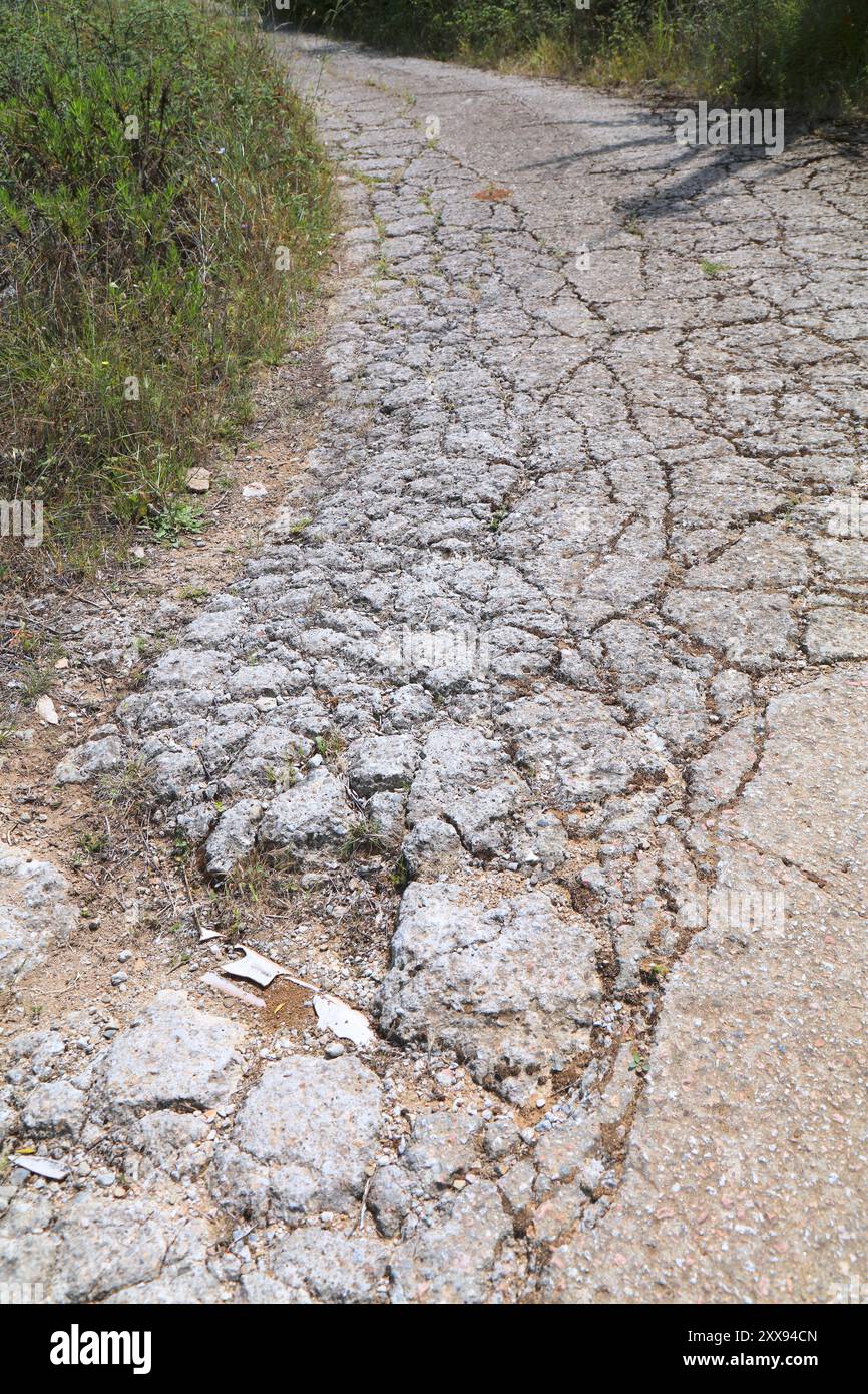Damaged concrete road surface with weeds in Sardinia, Italy ...