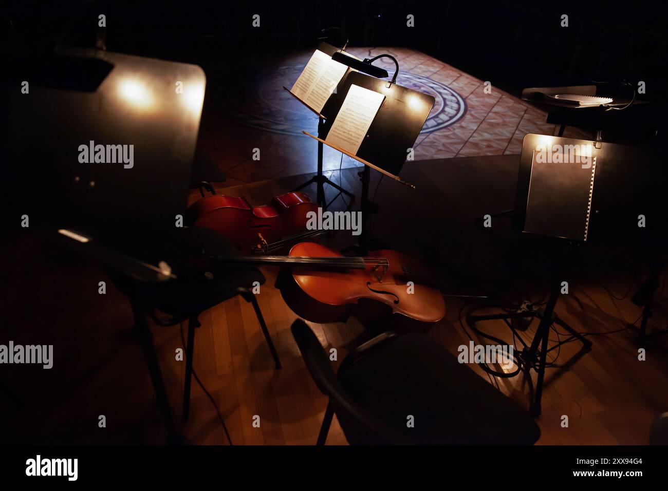 Violin and cello lie on stage during a break in a concert Stock Photo ...