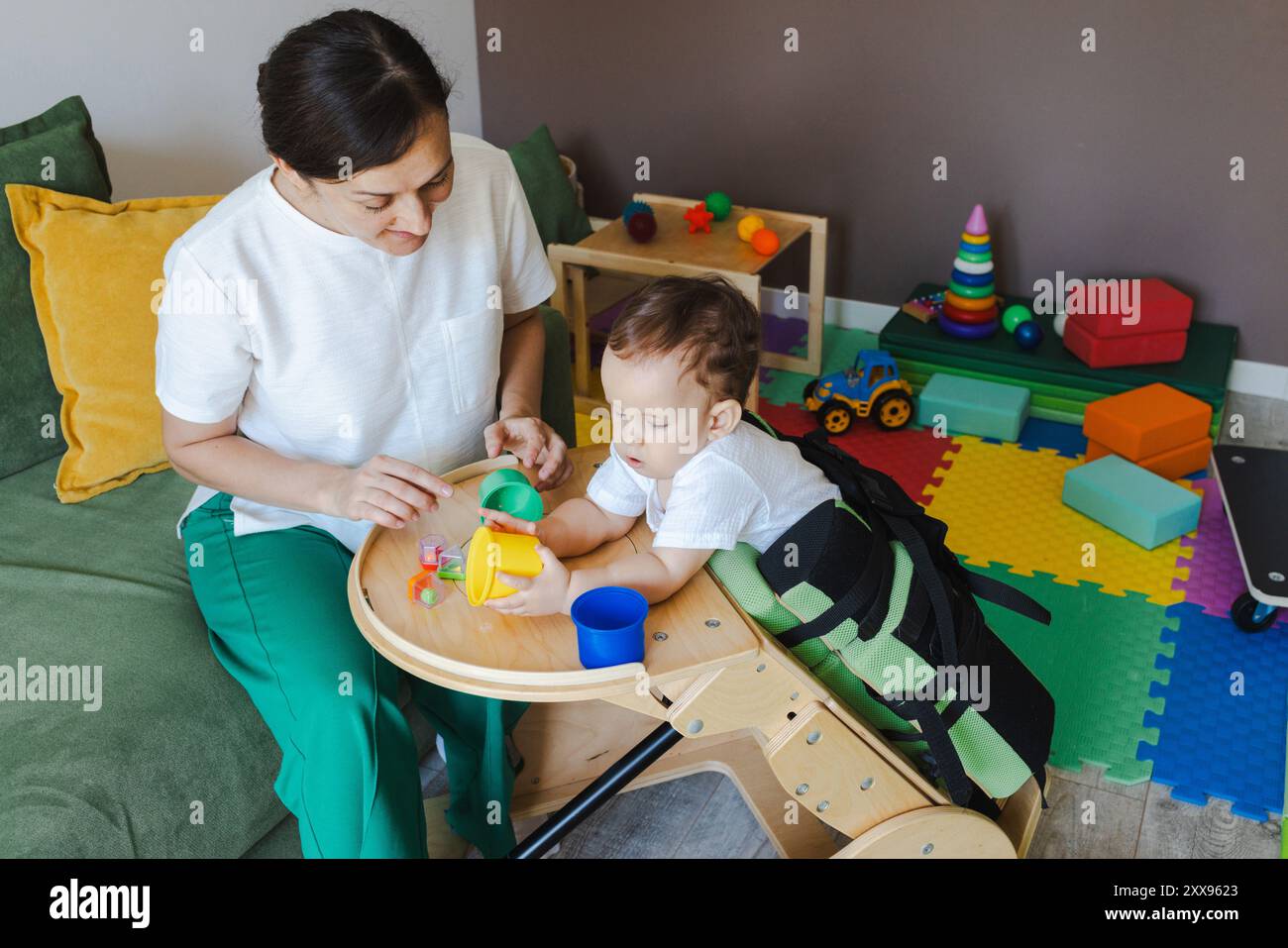 Physiotherapy verticalizer. Little boy spends useful time standing in ...