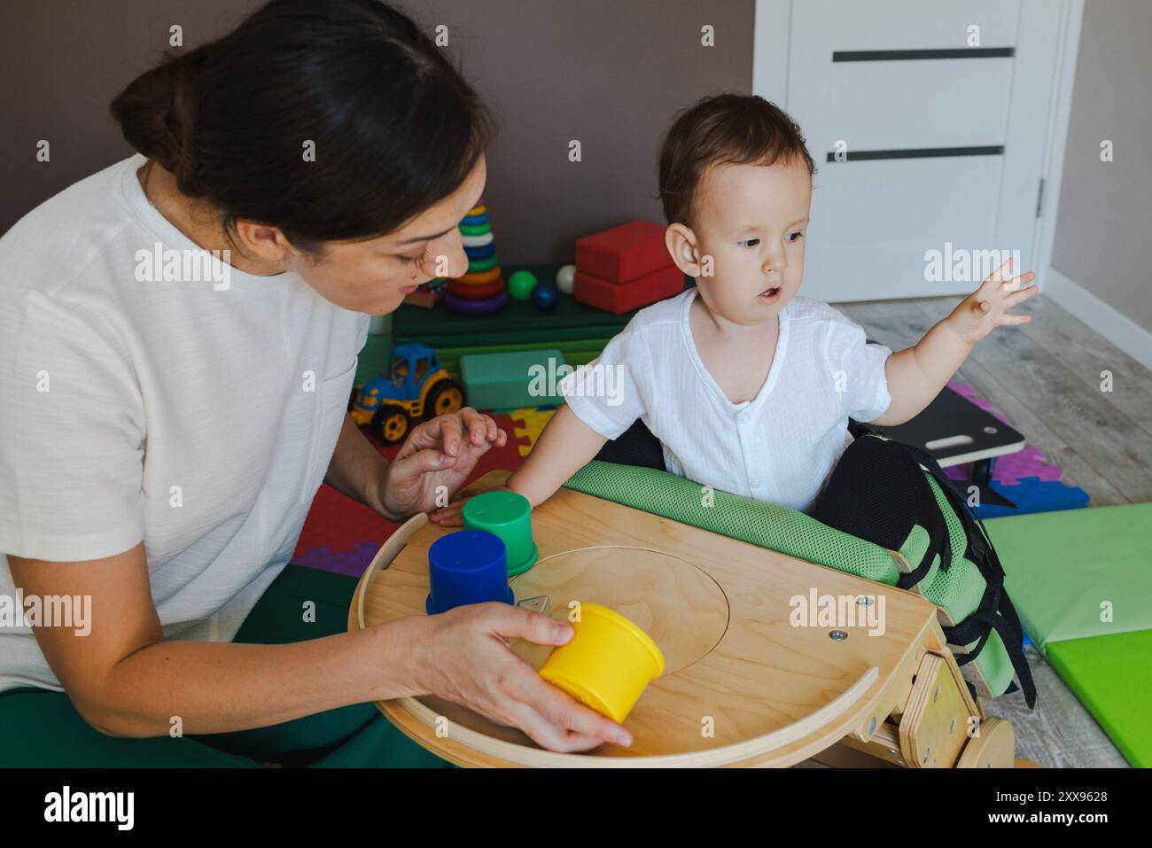 Handsome little boy with movement disorders standing rehab equipment ...