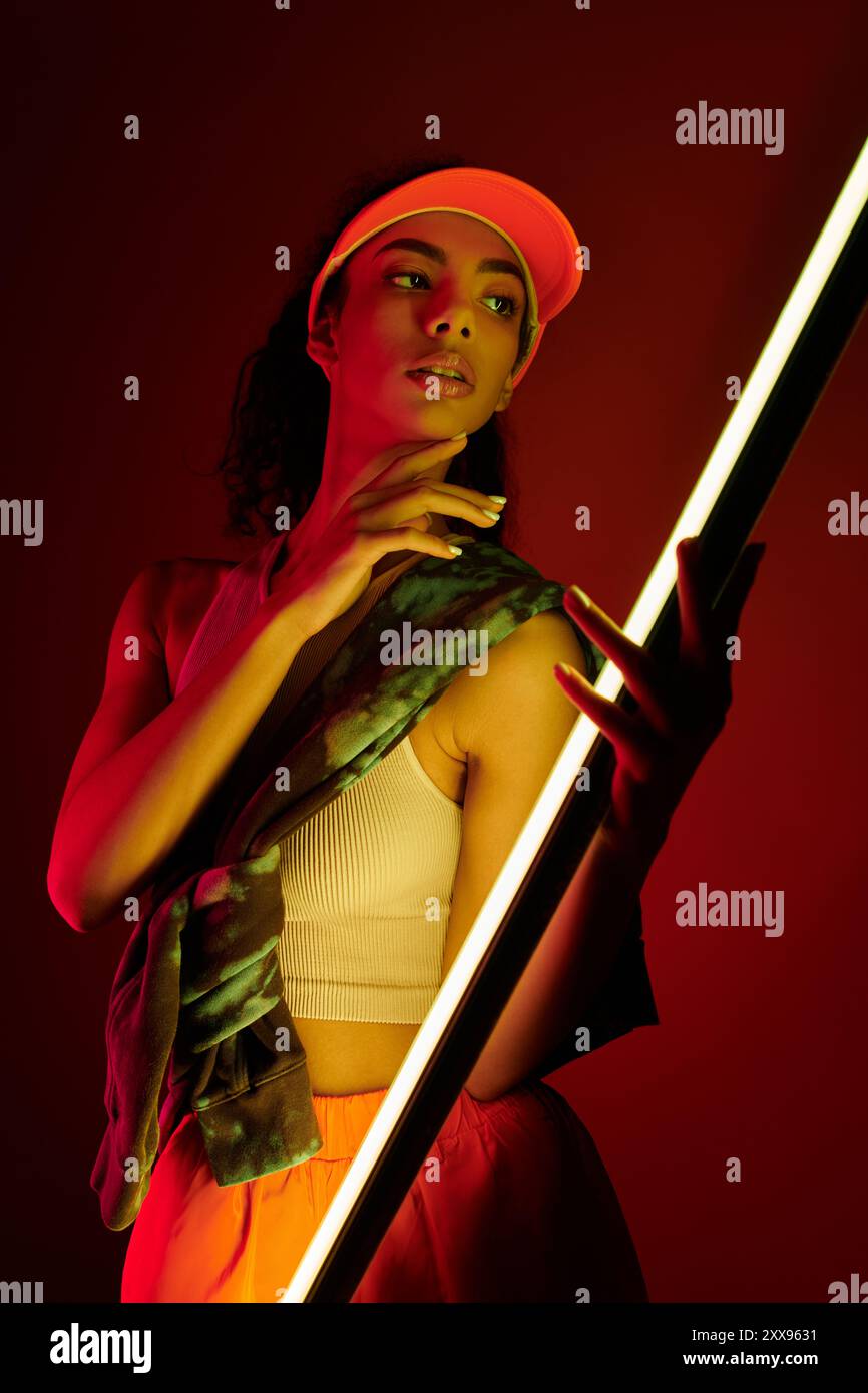 A young woman in a studio setting, bathed in neon lights, strikes a ...