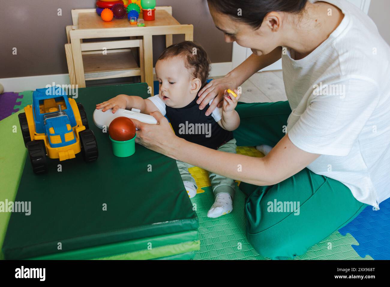 Young boy with muscle weakness engages in physical therapy while ...