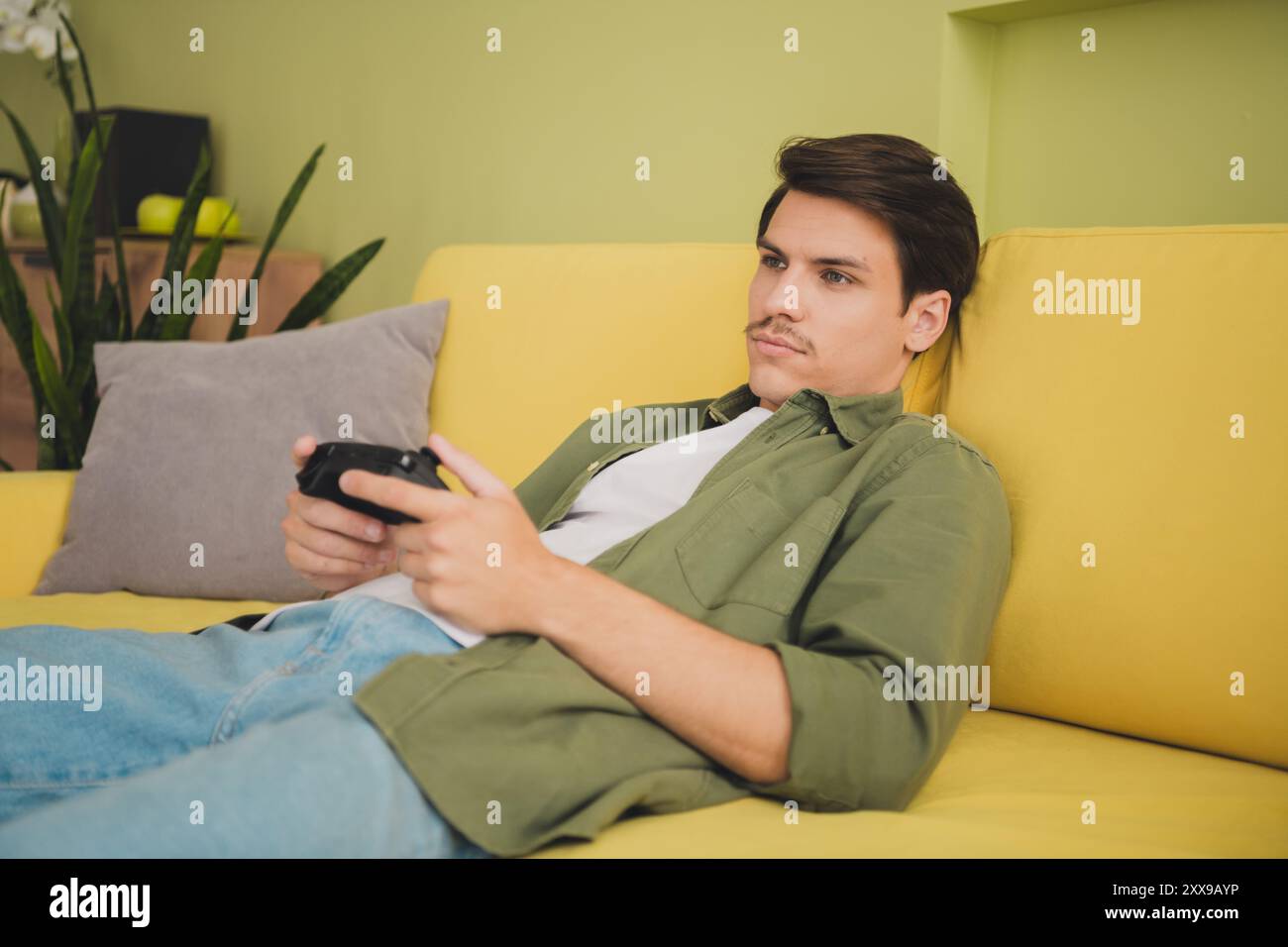 Photo of young guy wearing trendy clothes sitting cozy yellow divan ...
