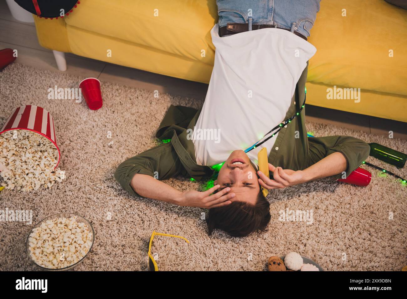 Photo of sad upset young guy after party celebration relax rest indoors ...