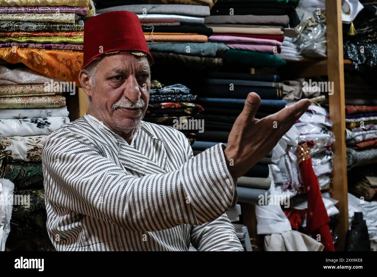 Jerusalem textile merchant Bilal Abu Khalaf stands in his shop in the Old City’s Christian ...
