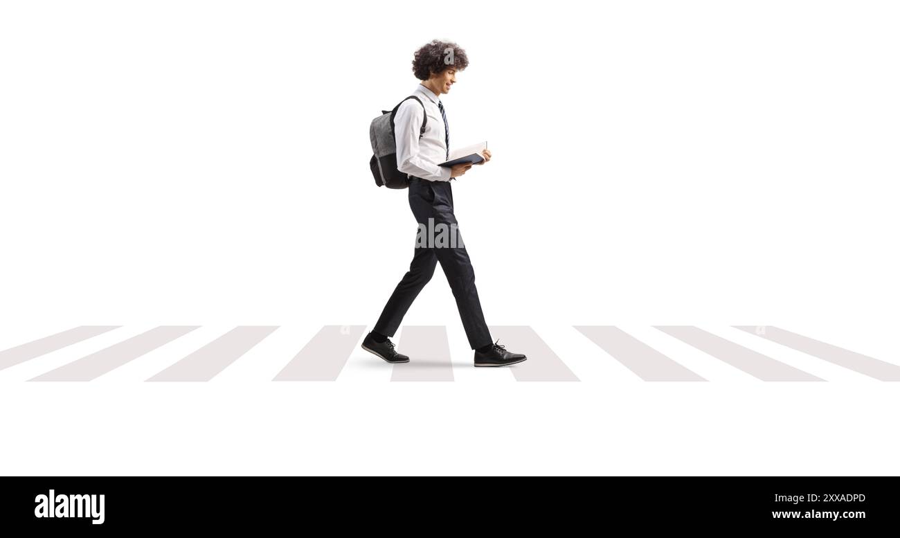 College student reading a book and walking at a pedestrian crossing ...